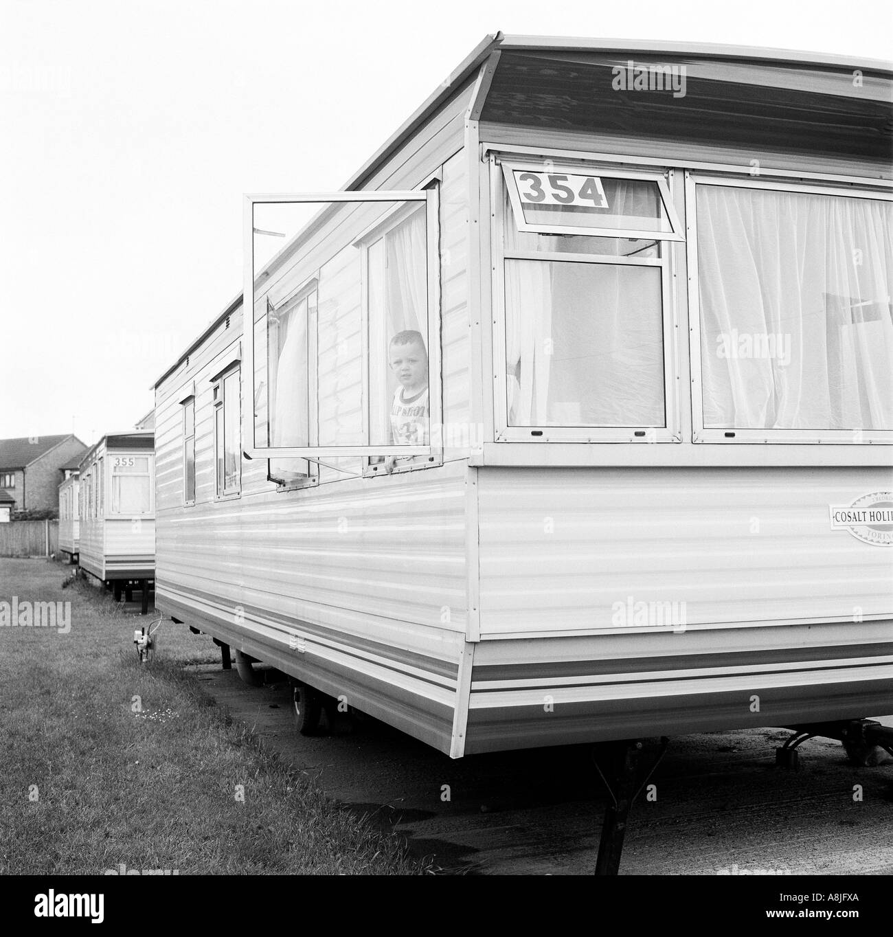 A boy stares out of the window of a caravan at a caravan park near ...