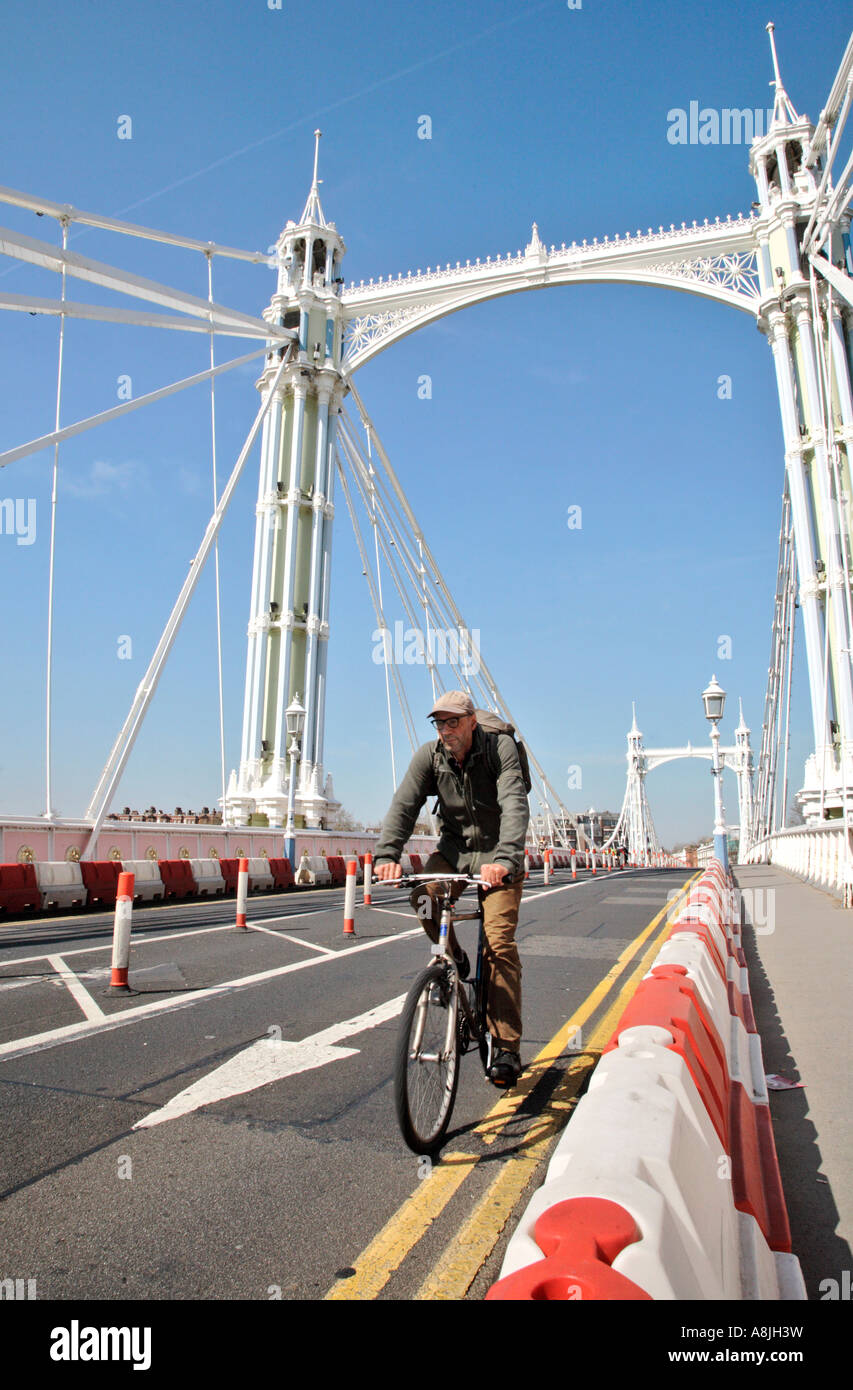 a man cycles across the Albert Bridge in London Stock Photo - Alamy