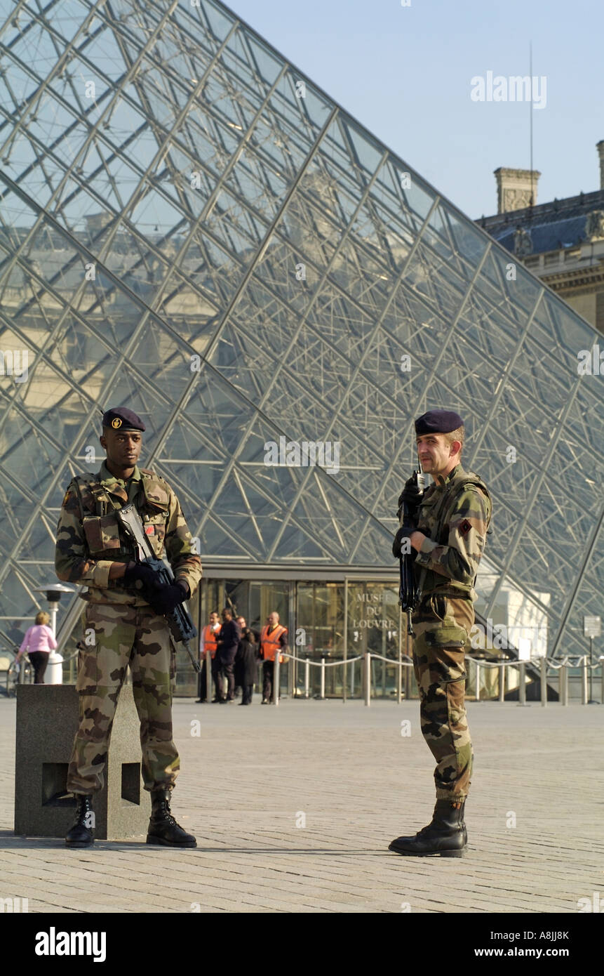Soldiers provide armed security outside the Louvre Glass Pyramid with ...