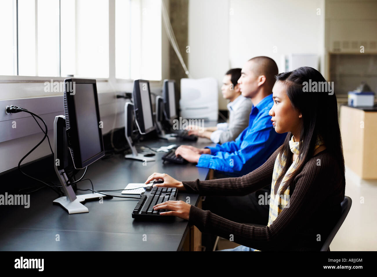 Side profile of a businesswoman and two businessmen sitting in an ...