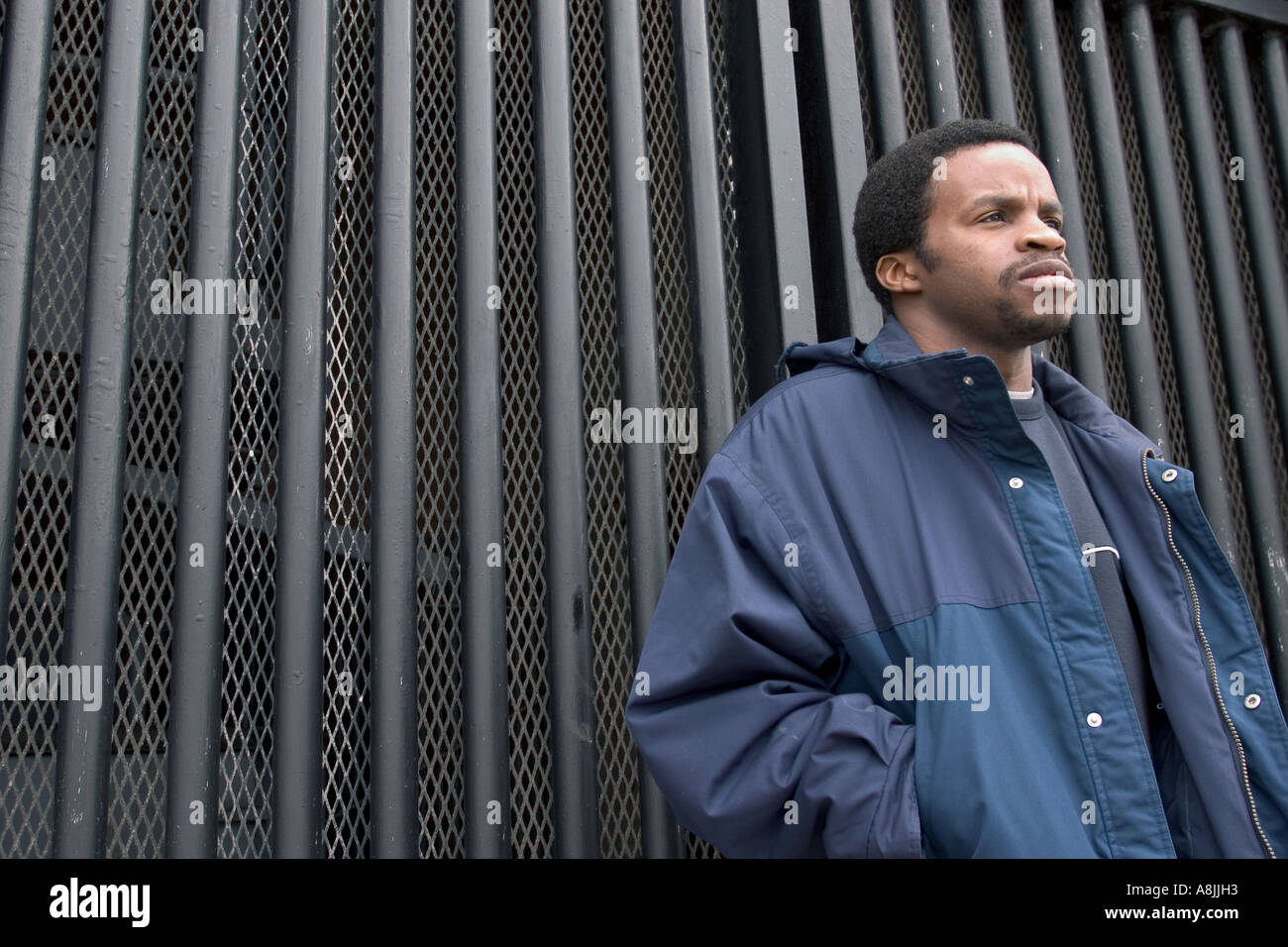 african male standing against railings Stock Photo - Alamy