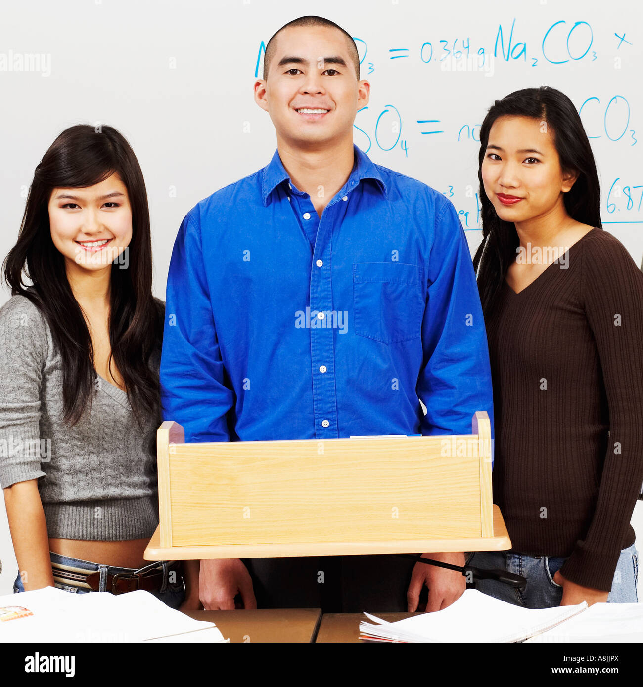 Portrait of a professor standing with his students in the classroom ...