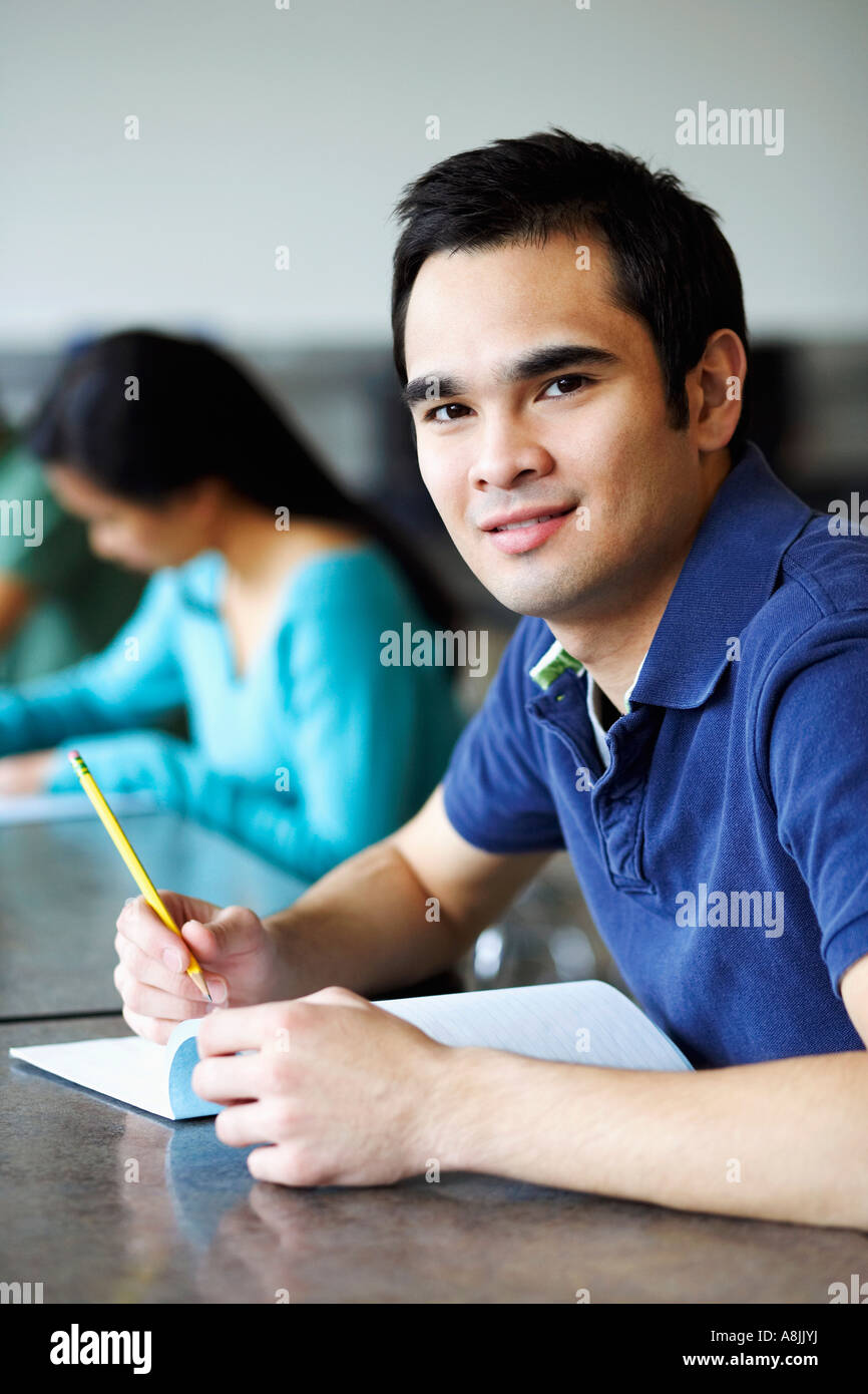 Portrait of a young man giving exams in a classroom and grinning Stock ...