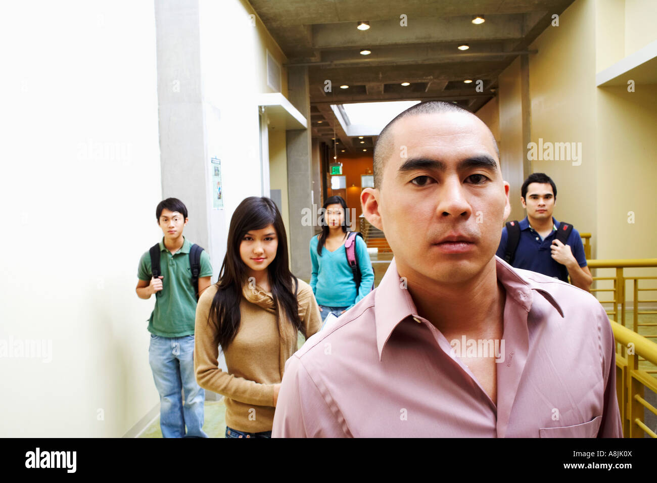 Portrait of a young man looking serious with two young women and two ...
