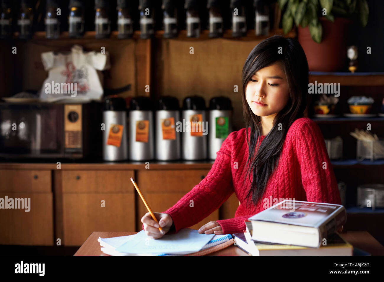Young woman writing on a sheet of paper Stock Photo - Alamy