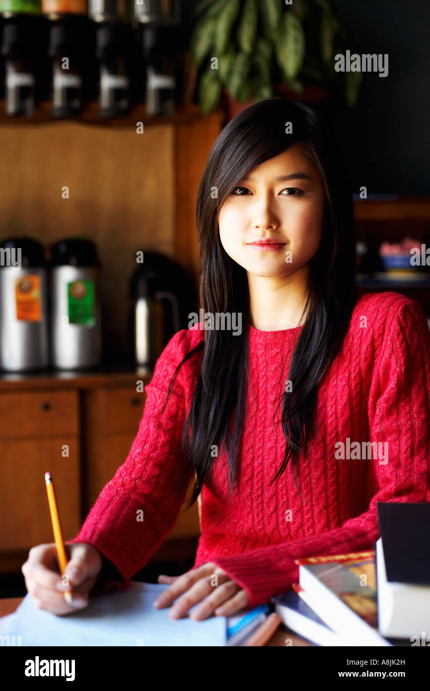 Portrait of a young woman writing on a sheet of paper Stock Photo - Alamy