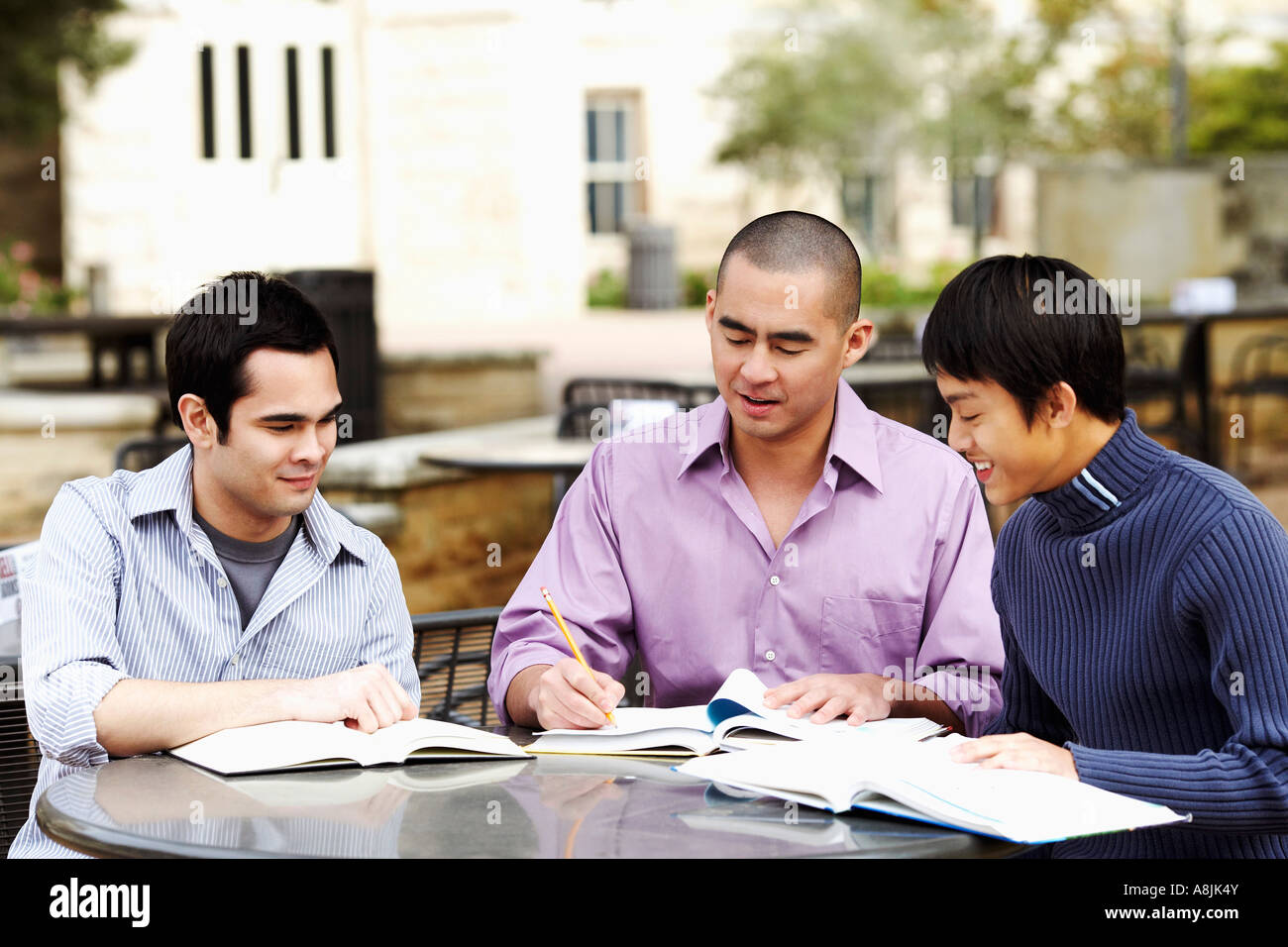 Three young men studying in a college campus and smiling Stock Photo ...