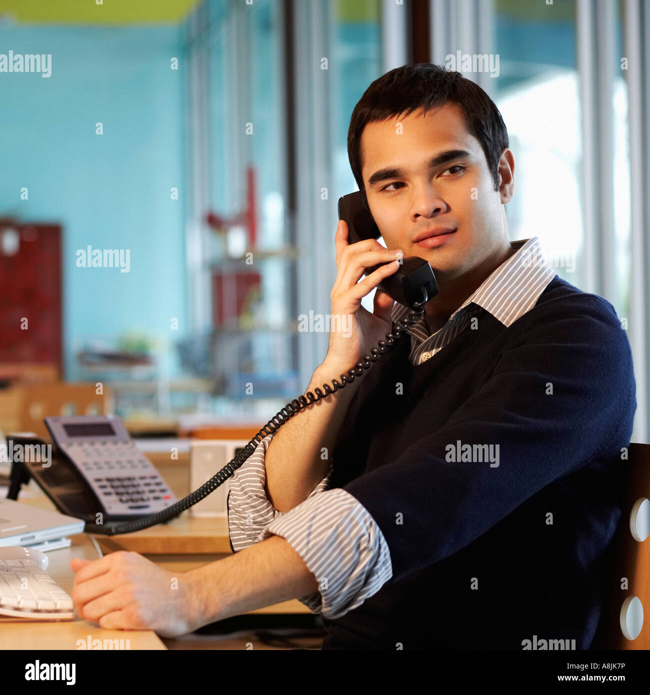 Side profile of a businessman talking on the telephone in an office ...