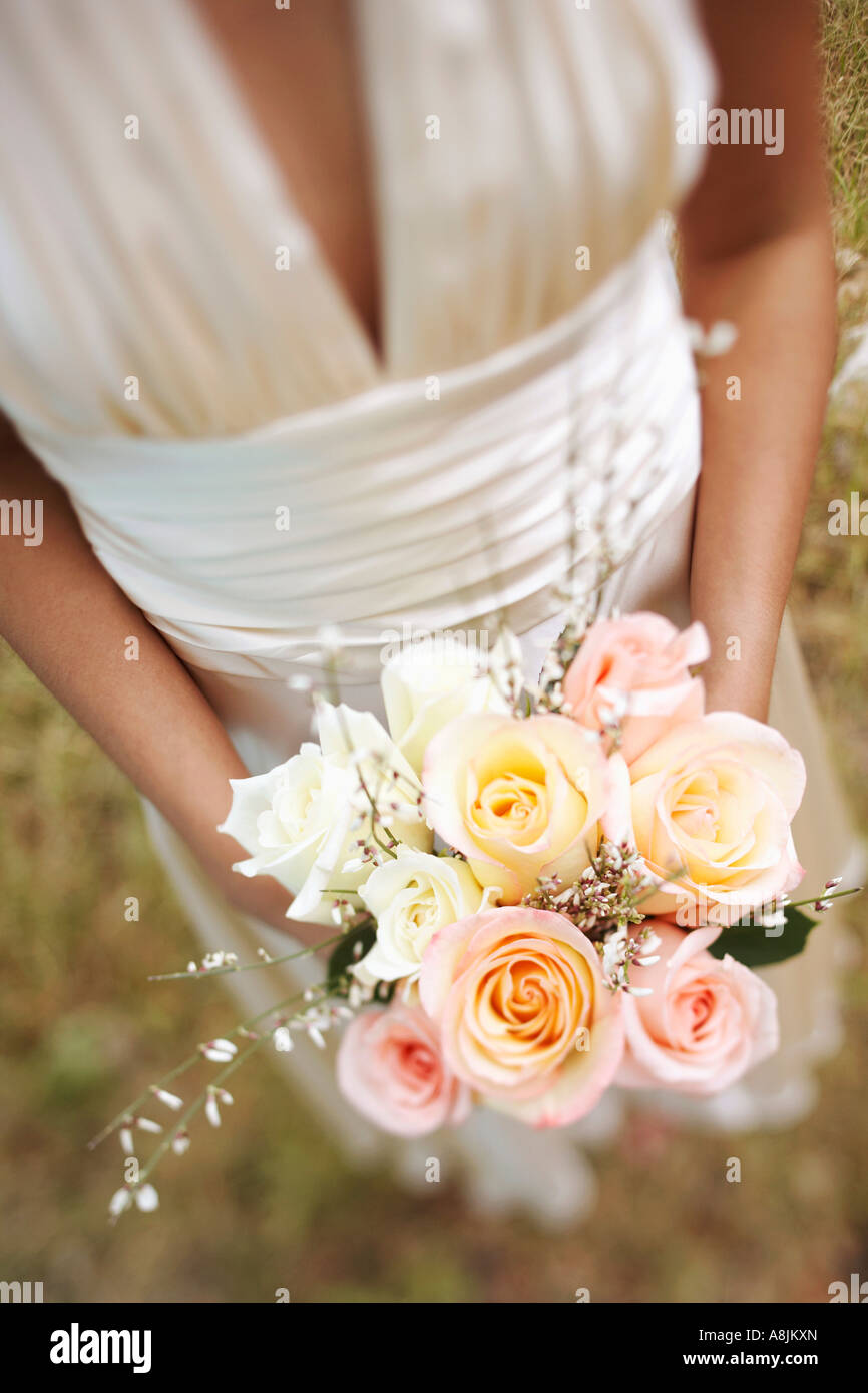Mid section view of a bride holding a bouquet of flowers Stock Photo ...