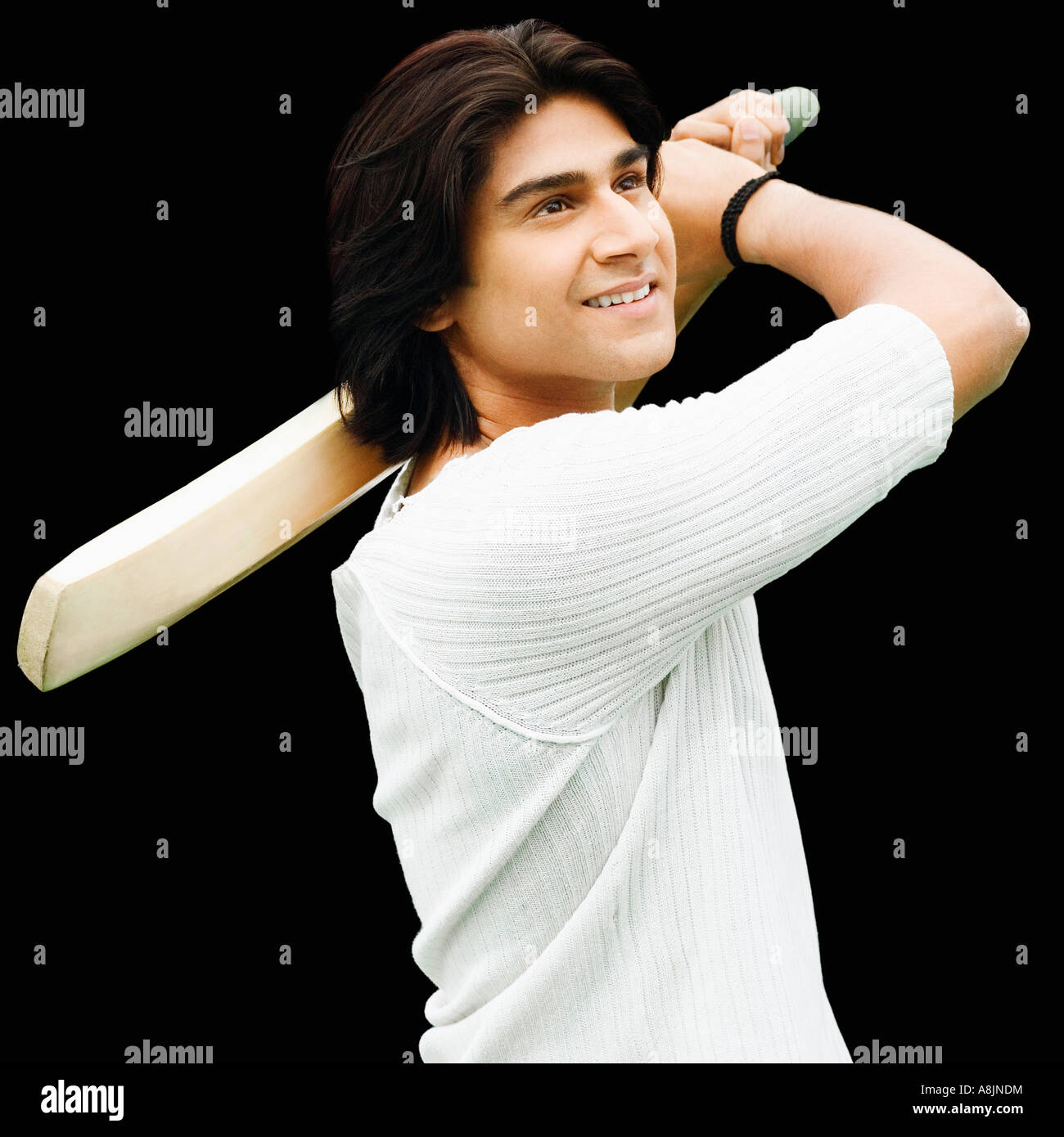 Close-up of a young man swinging a cricket bat Stock Photo - Alamy