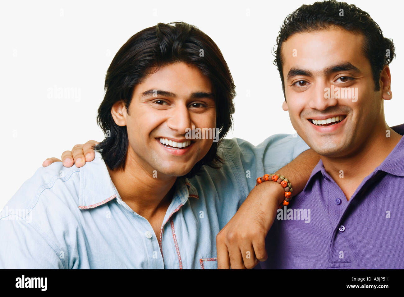 Portrait of two young men smiling with their arm around each other ...