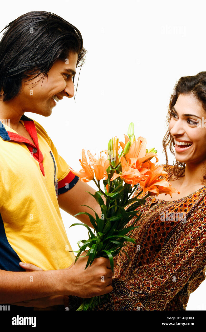 Young man giving a bunch of flower to a young woman and smiling Stock ...