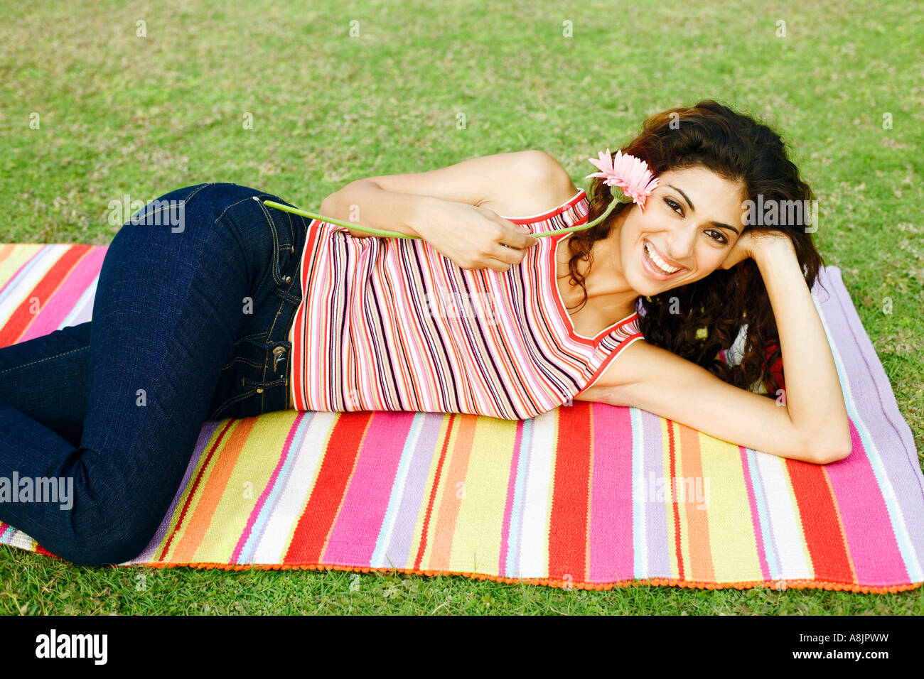 Portrait of a young woman lying on a mat and smiling Stock Photo - Alamy