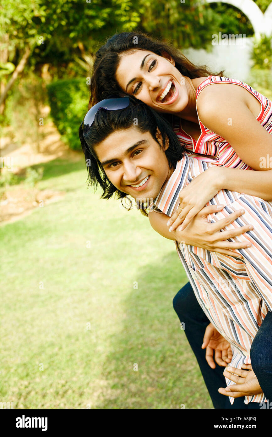 Young woman riding piggyback on a young man Stock Photo - Alamy