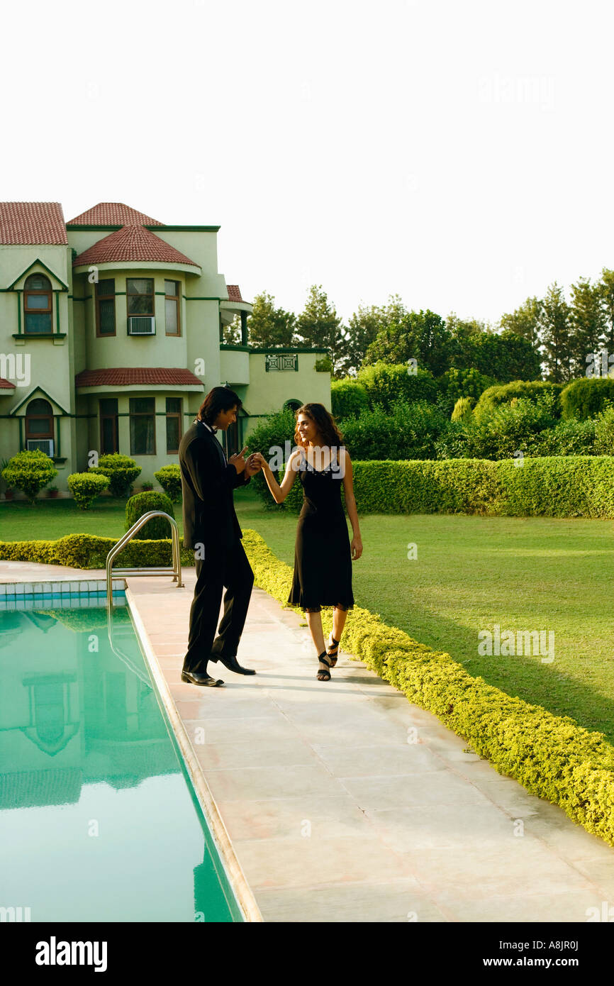 Young couple walking at the poolside Stock Photo - Alamy