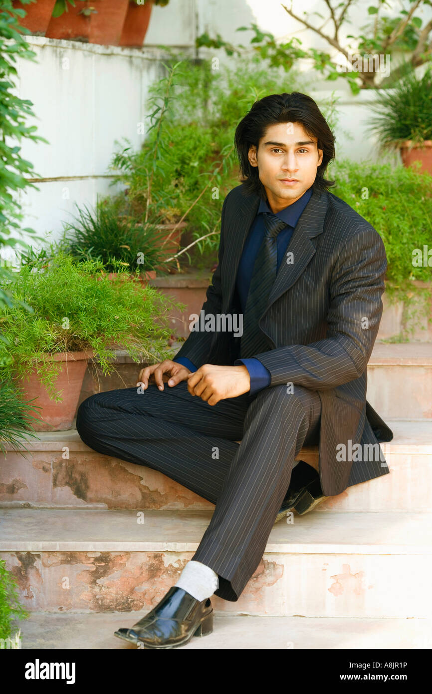 Portrait of a young man sitting on steps Stock Photo - Alamy