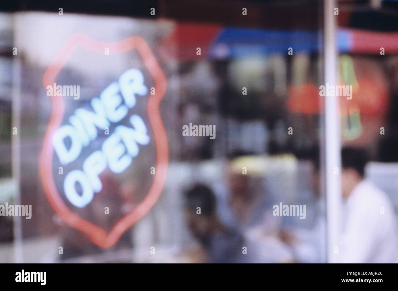Defocussed image of window with illuminated neon sign stating Diner ...