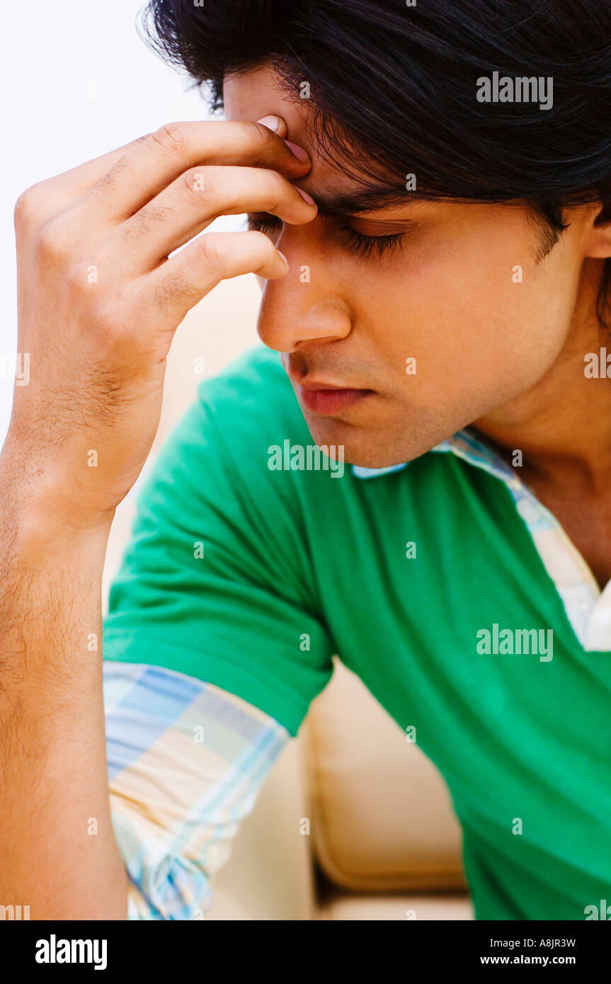 Close-up of a young man with his hand on his forehead Stock Photo - Alamy