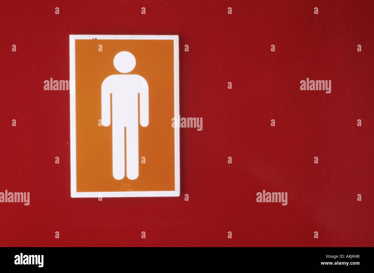 Orange and white Man icon on red door of public toilet Stock Photo - Alamy