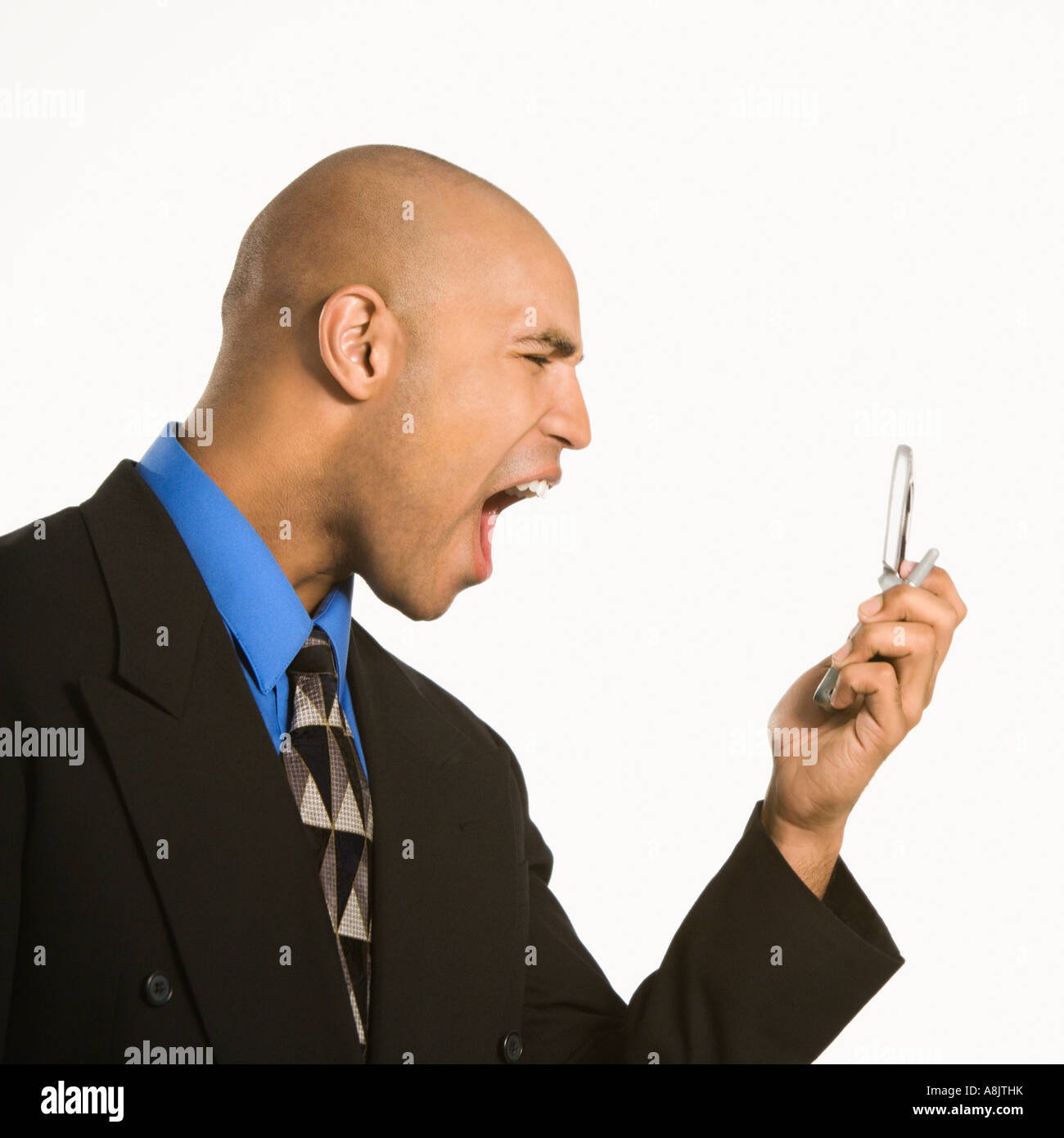 Head and shoulder portrait of African American man in suit yelling at ...