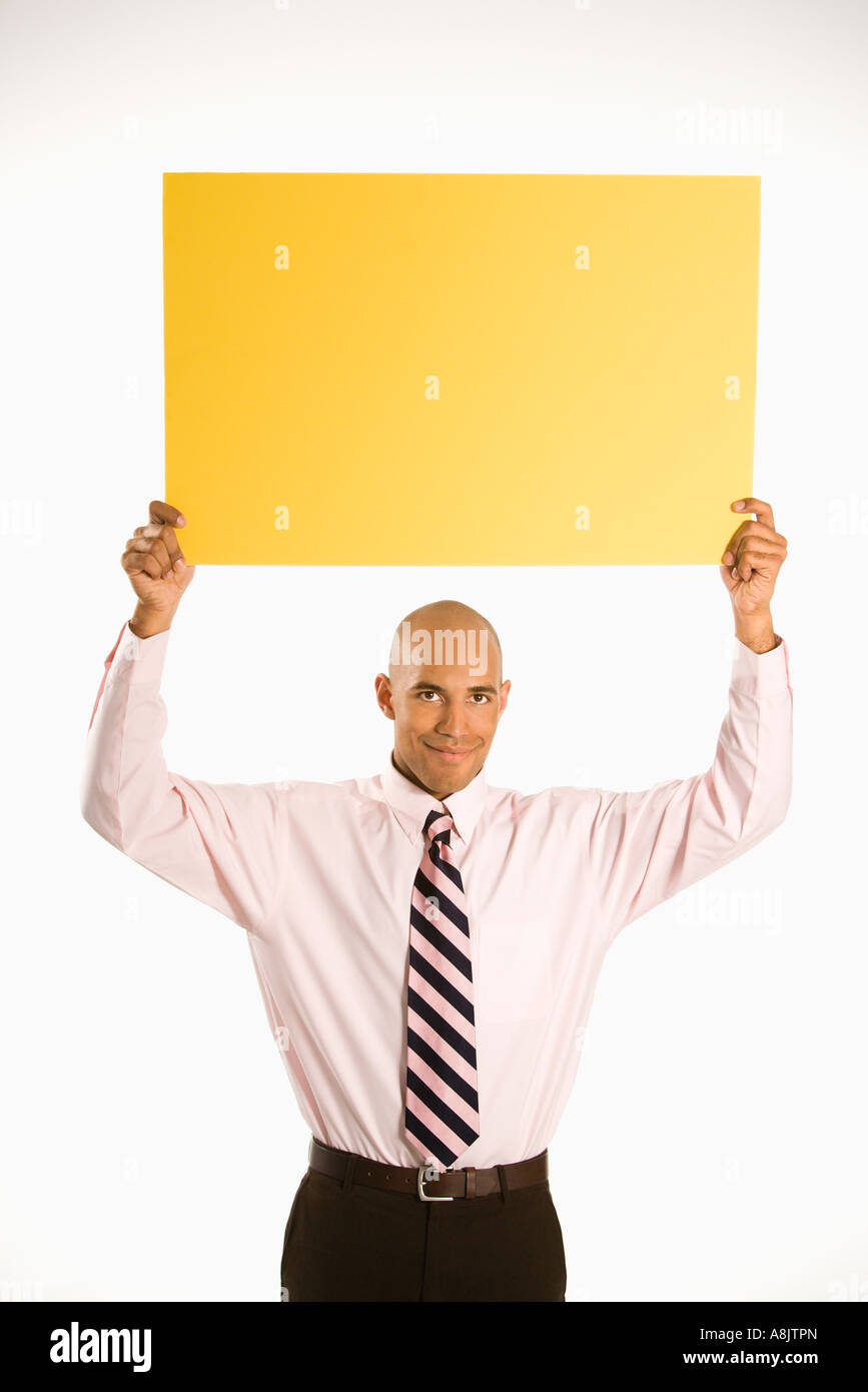 African American man holding blank yellow sign overhead standing ...