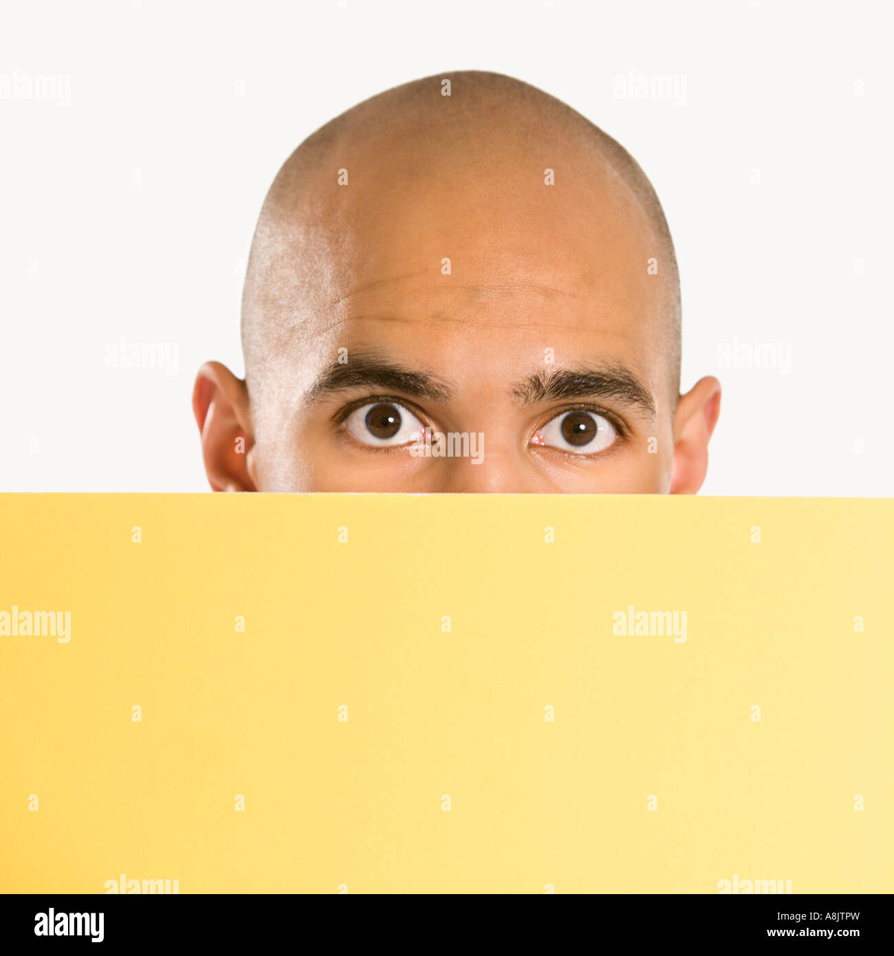 African American man peeking over blank yellow sign Stock Photo - Alamy