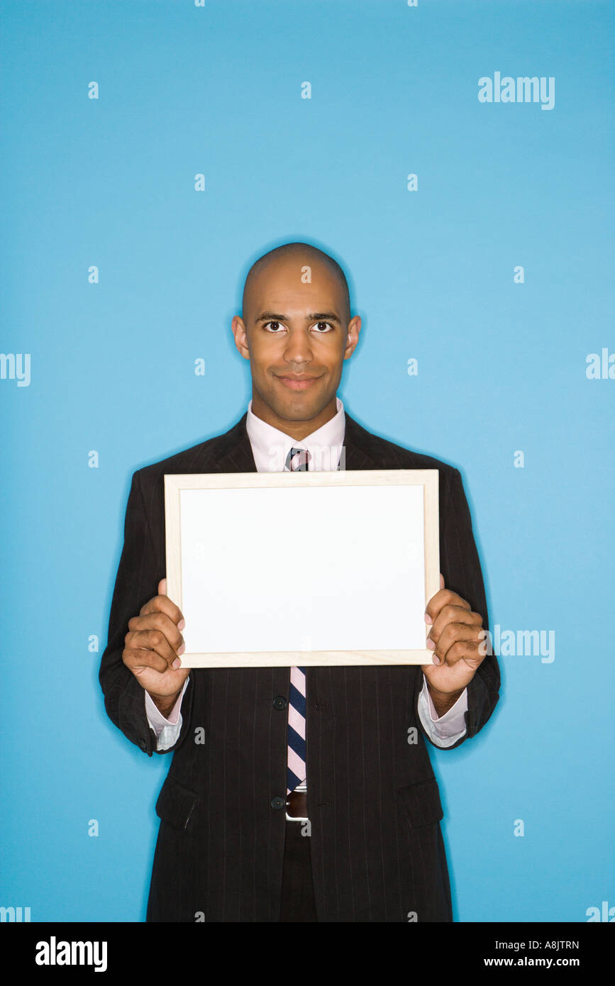 African American man holding blank sign against blue background Stock ...