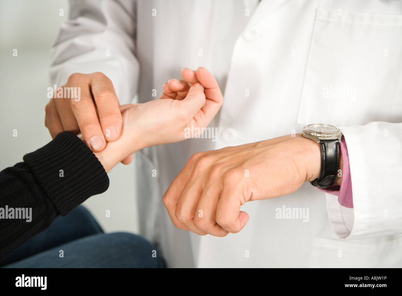 Doctor taking patients pulse Stock Photo - Alamy