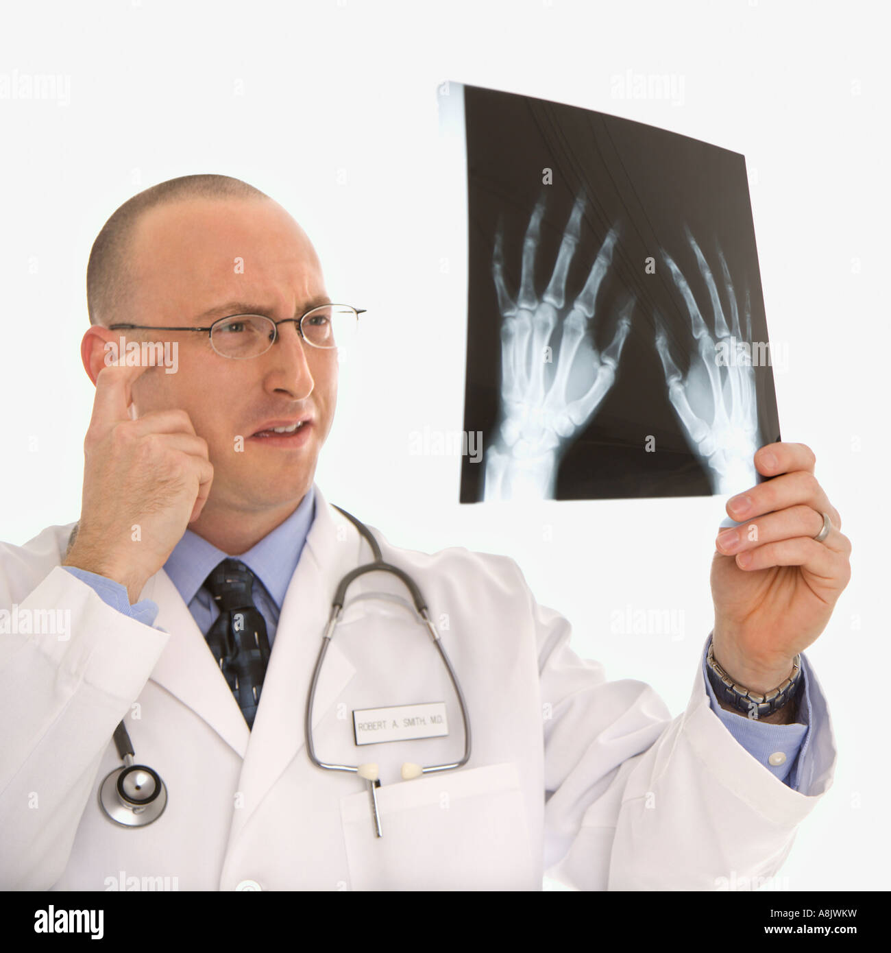 Caucasian mid adult male physician holding up hand xrays looking ...