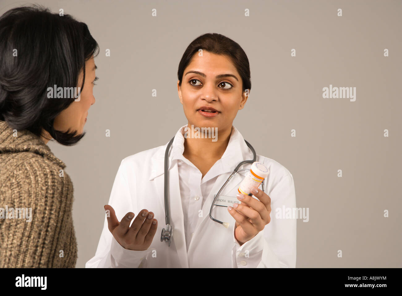 Indian woman doctor explaining medication to Asian woman patient Stock ...