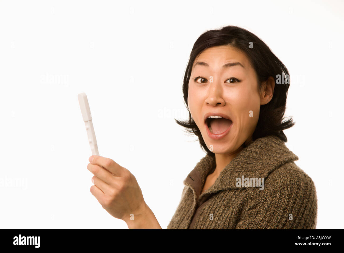 Asian mid adult woman holding up pregnancy test looking excited Stock ...