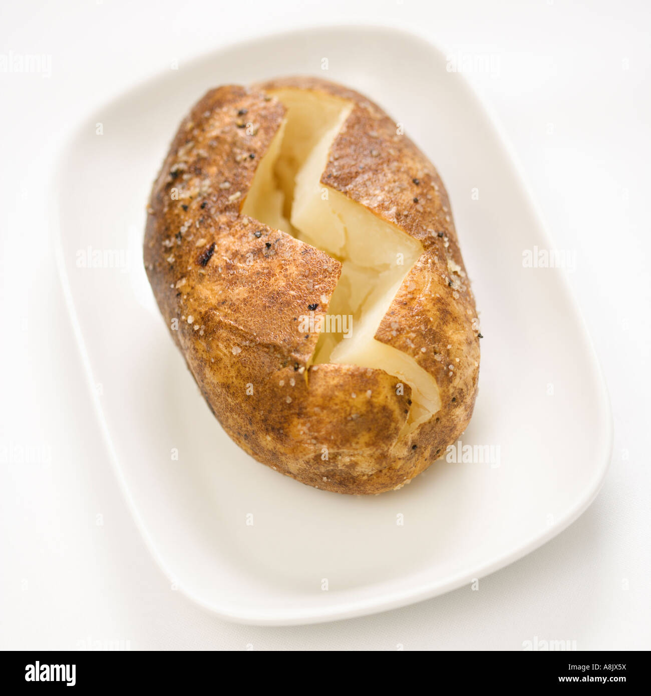 Plain baked potato sliced down the middle on a plate Stock Photo - Alamy