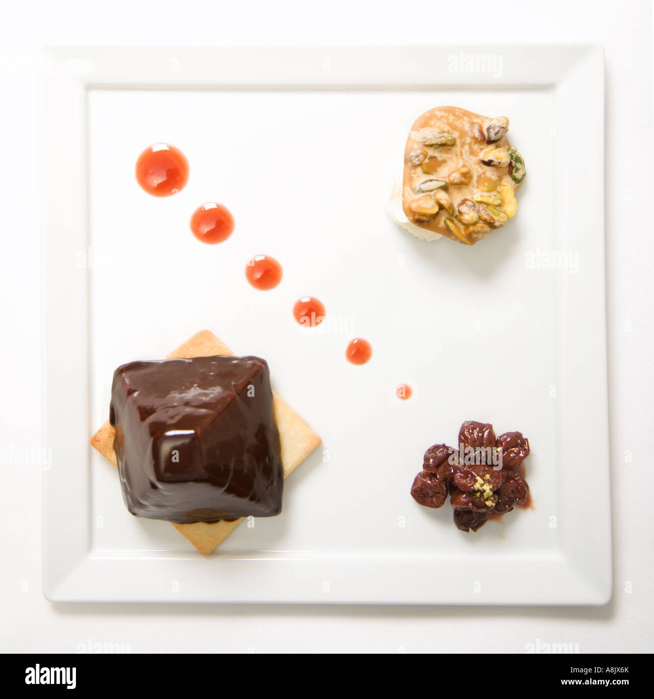 Chocolate cheesecake pyramid with dried cherries and pistachio praline ...