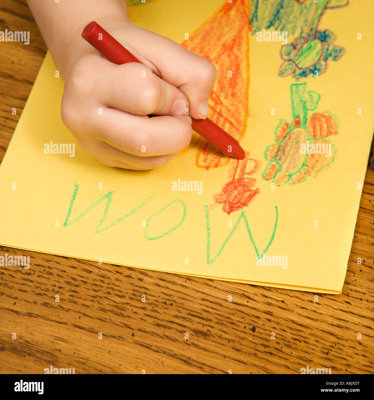 Caucasian boy drawing on yellow paper with crayons Stock Photo - Alamy