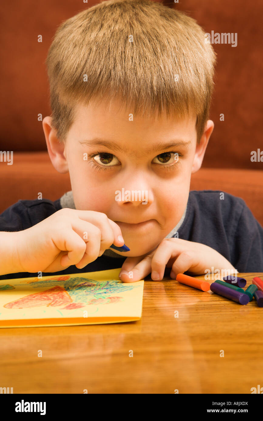Caucasian boy drawing with crayons and looking at viewer Stock Photo ...