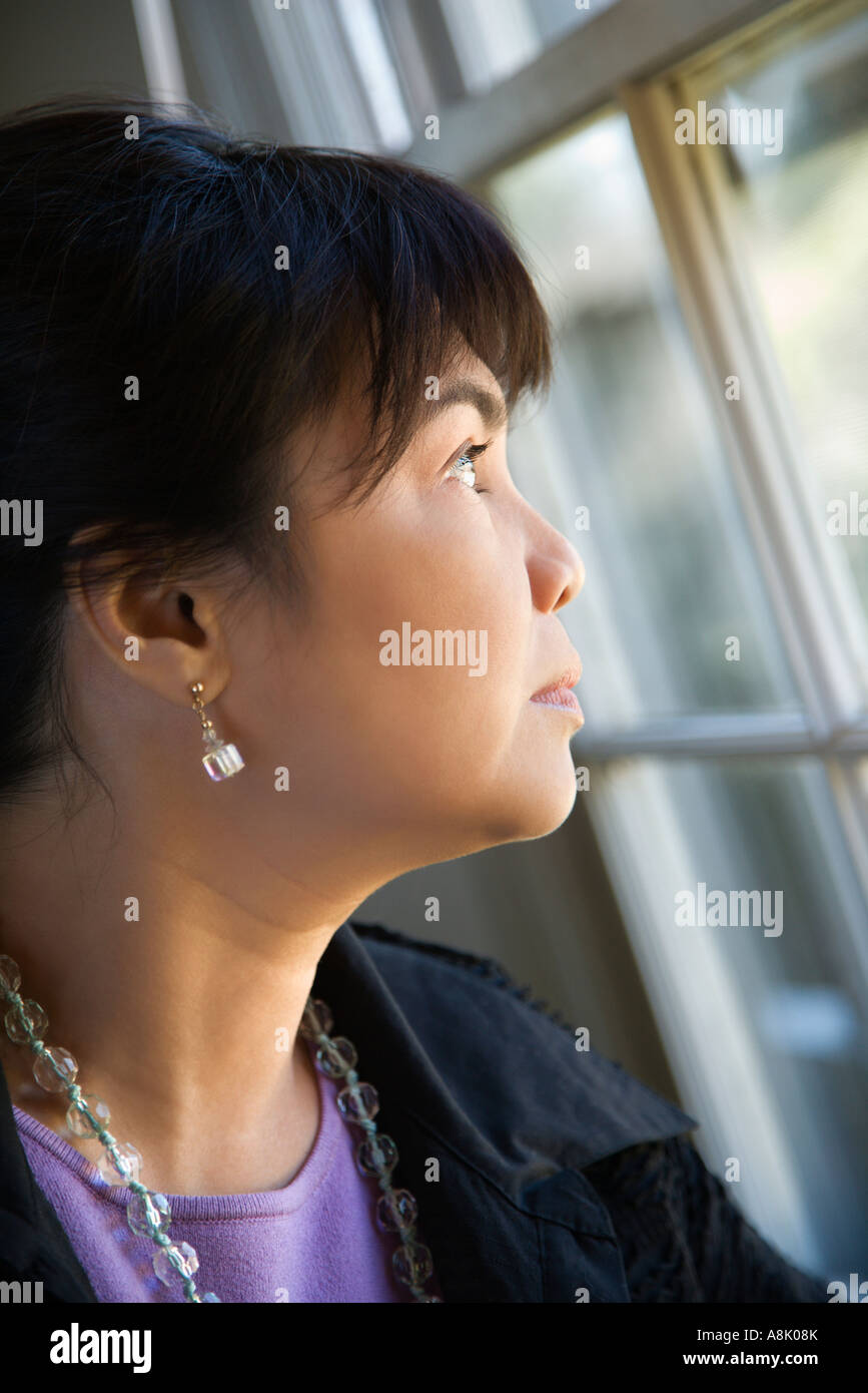 Portrait of Asian Filipino woman gazing out window Stock Photo - Alamy