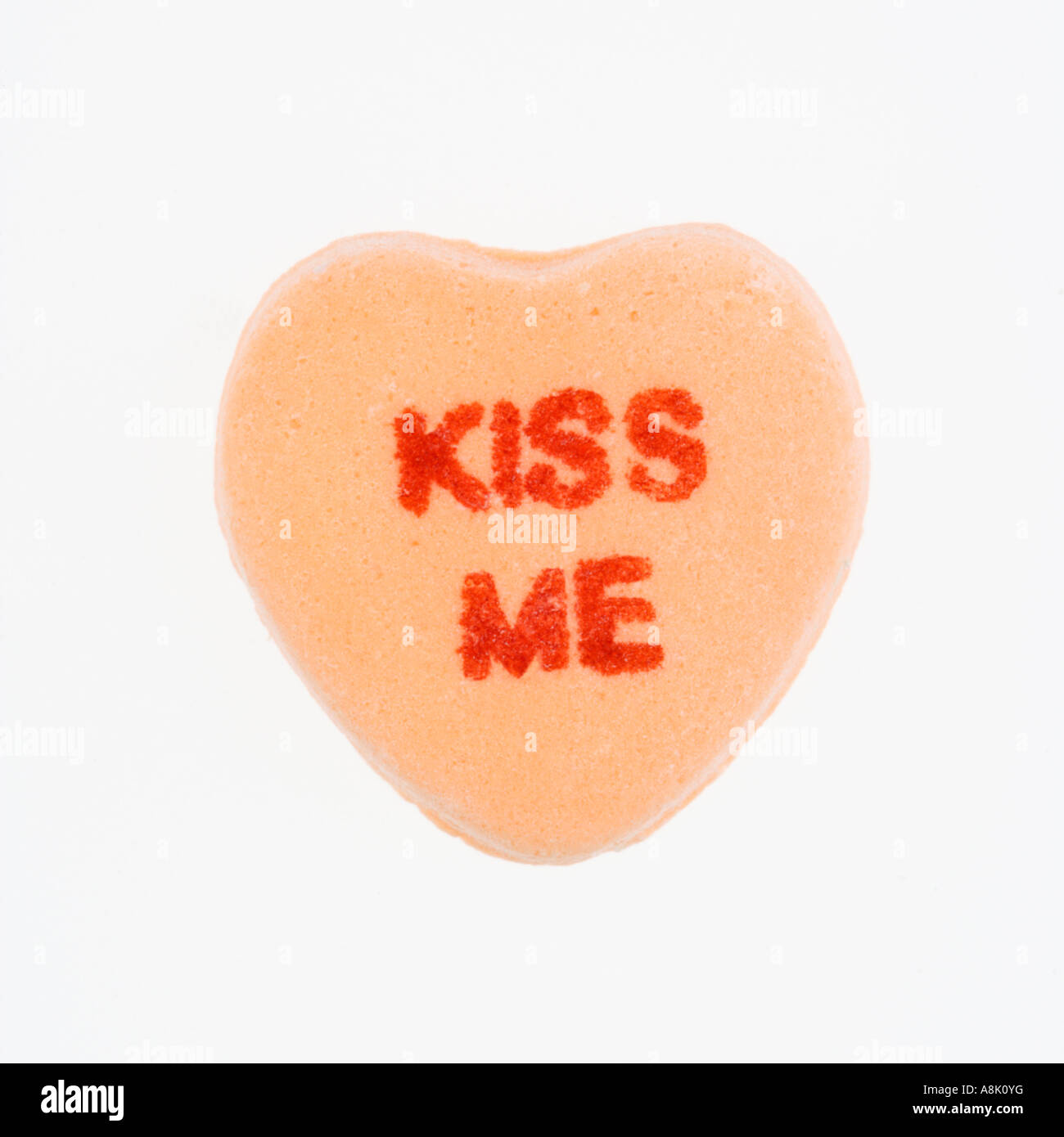 Orange candy heart that reads kiss me against white background Stock ...