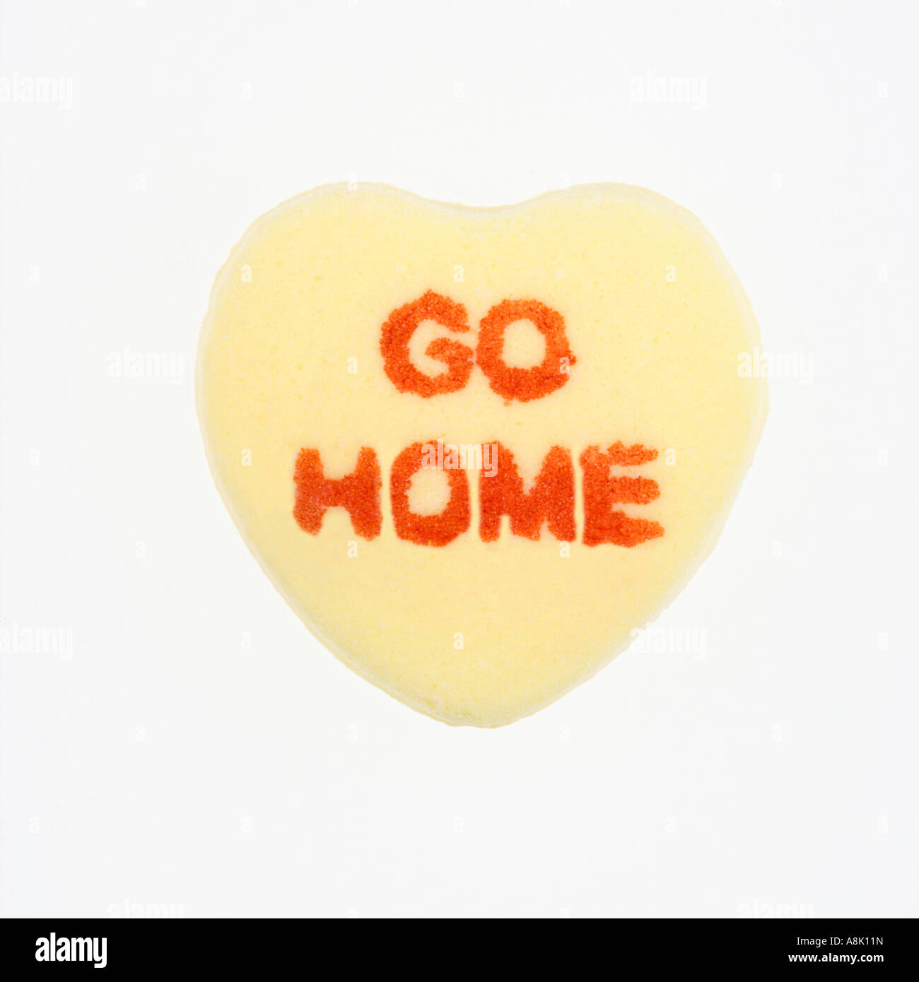 Yellow candy heart that reads go home against white background Stock ...