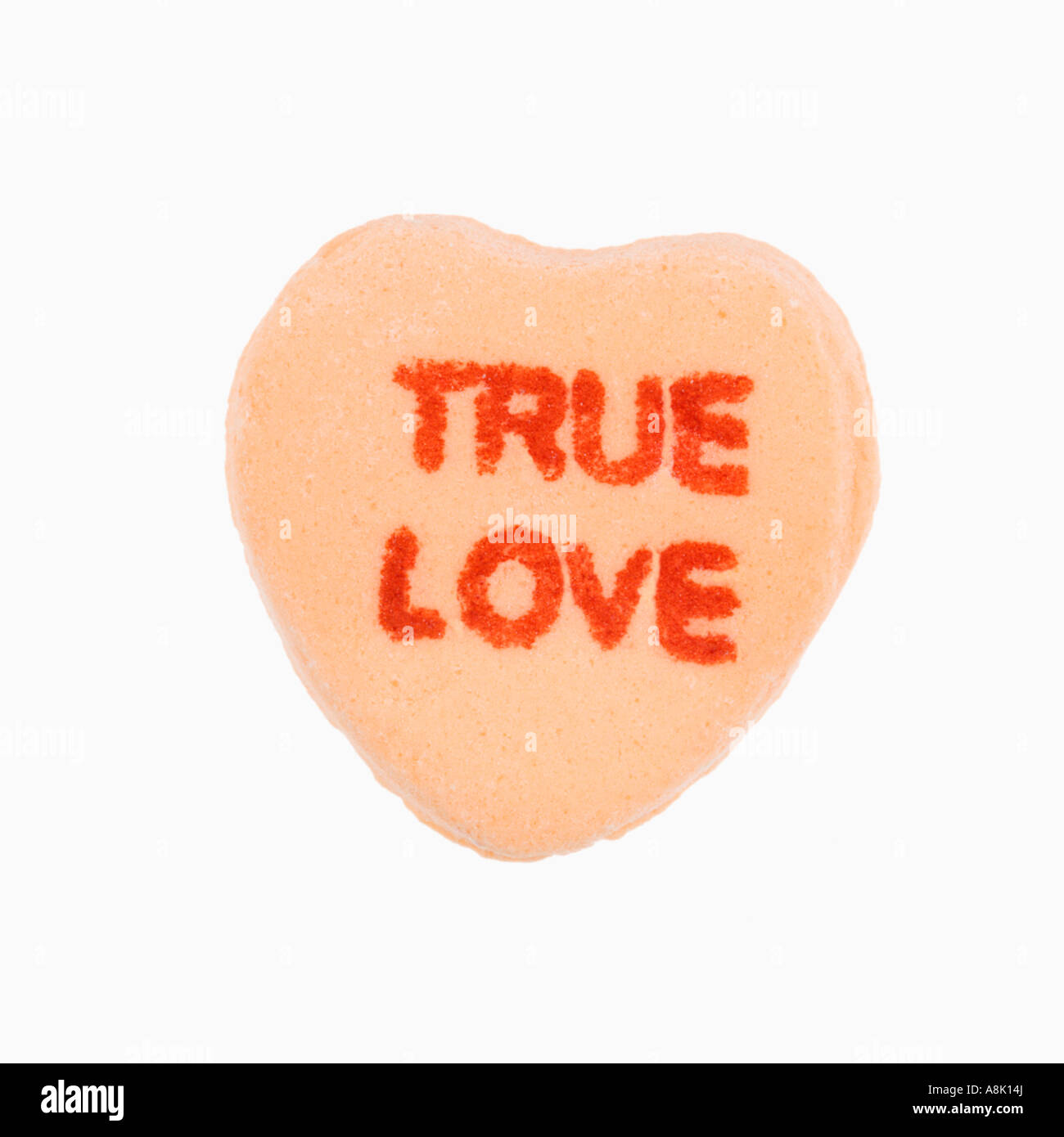 Orange candy heart that reads true love against white background Stock ...