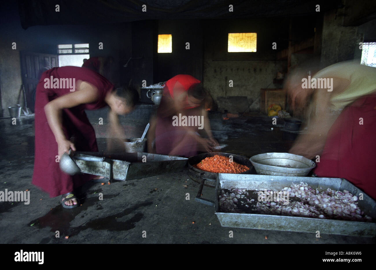 A group of Tibetan monks make lunch in a kitchen for hundreds of other ...