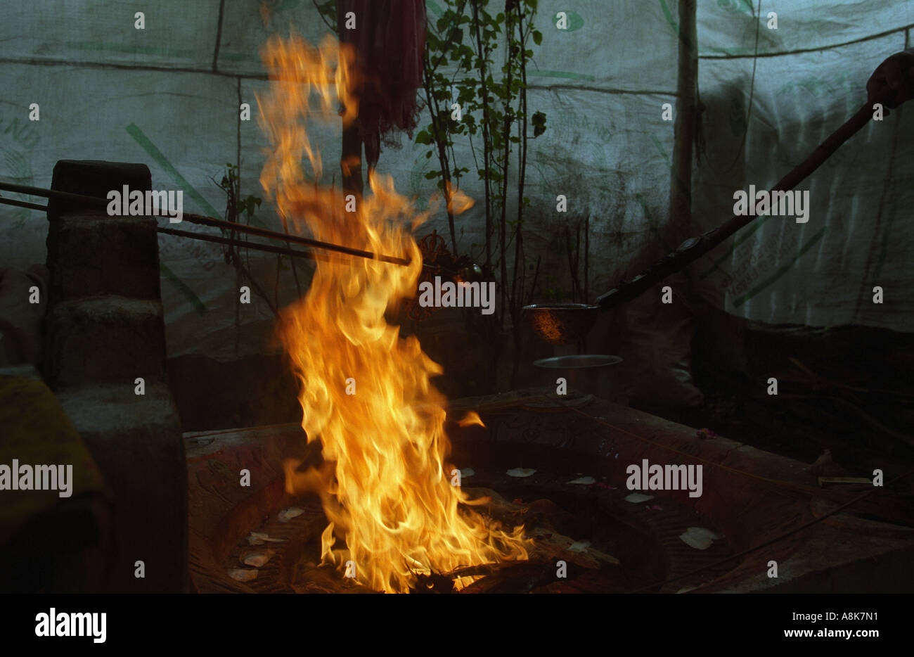 A tantric tibetan buddhist makes a fire puja offering at the end of a ...