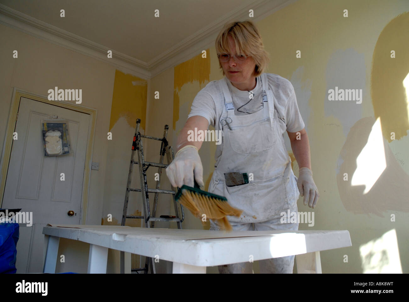 Woman DIY papering her room walls with lining paper Stock Photo - Alamy