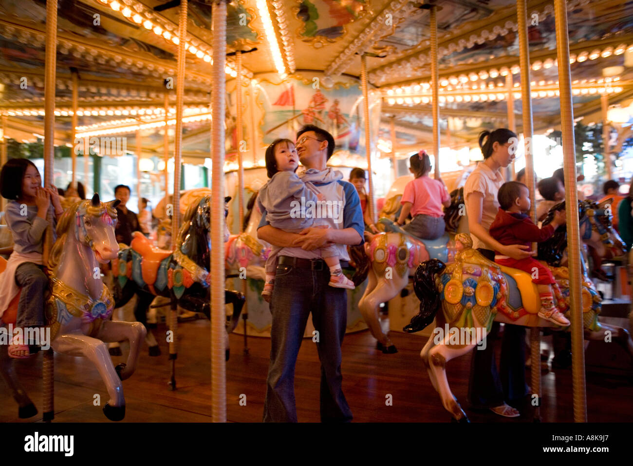 Father holding daughter at the carousel ride at the Genting Highlands ...