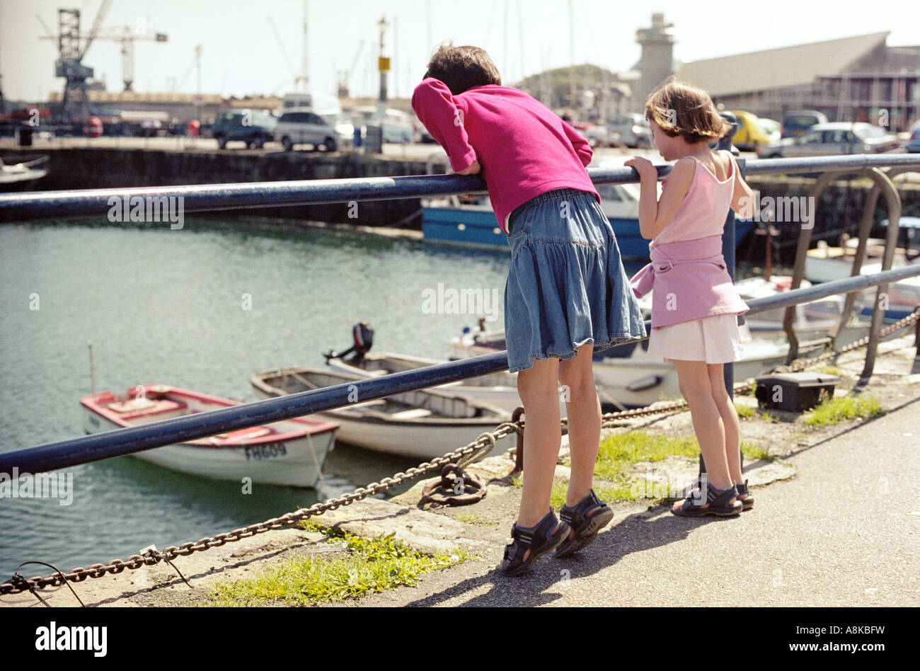 Children leaning over railings looking at the boats in a harbour Stock ...