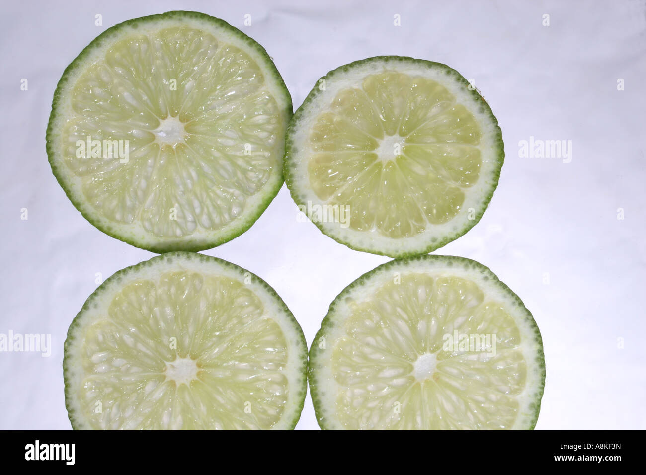 Slices of lime with a light background Stock Photo - Alamy