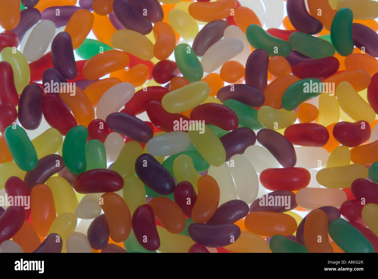 Horizontal close up of lots of identical multi coloured jelly beans ...