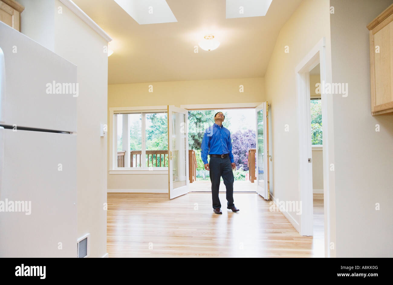 Asian man looking around new house Stock Photo - Alamy
