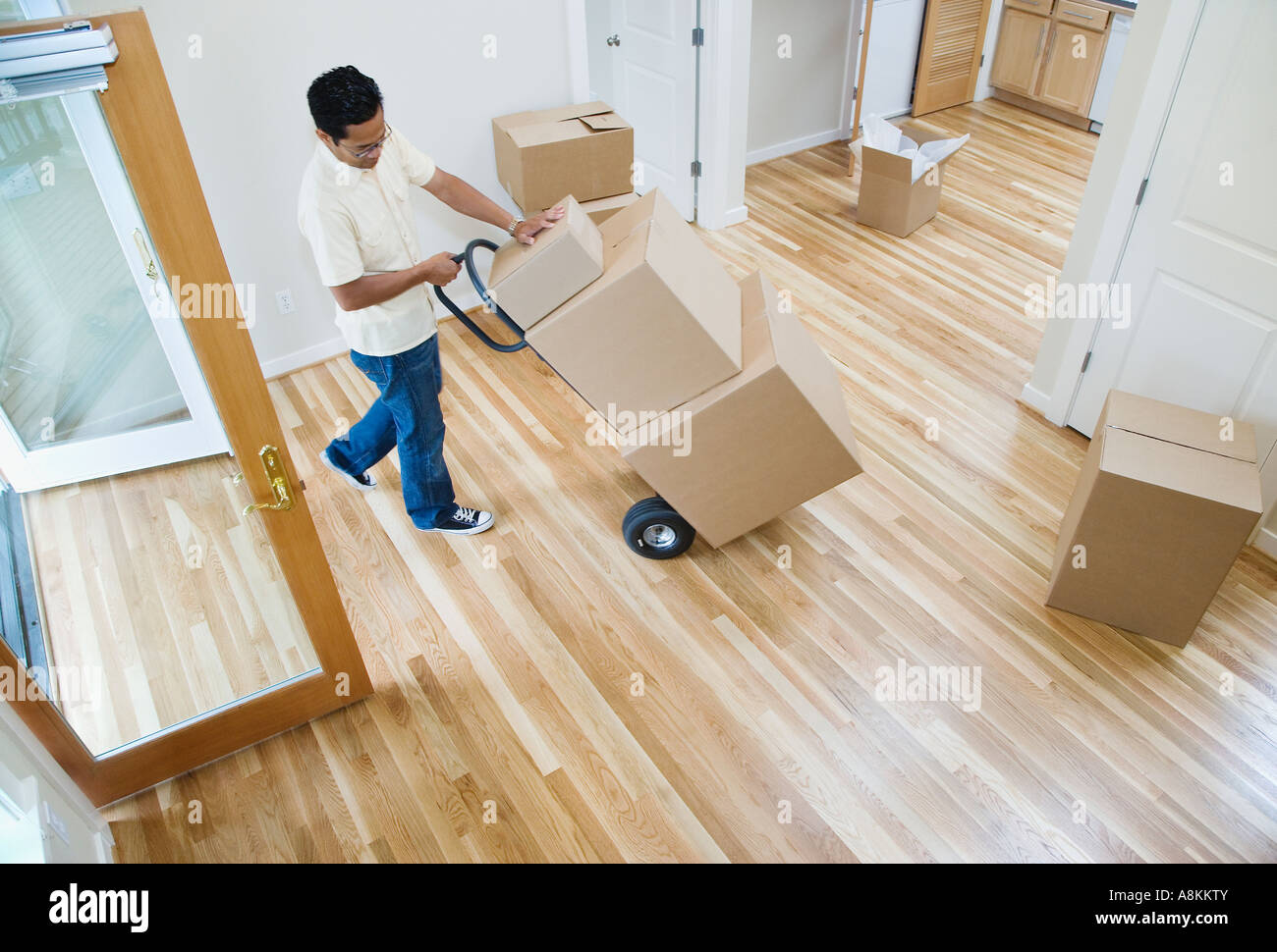Asian man moving boxes in new house Stock Photo - Alamy