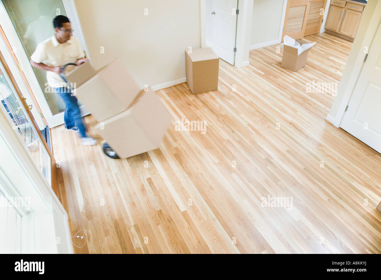 Asian man moving boxes in new house Stock Photo - Alamy