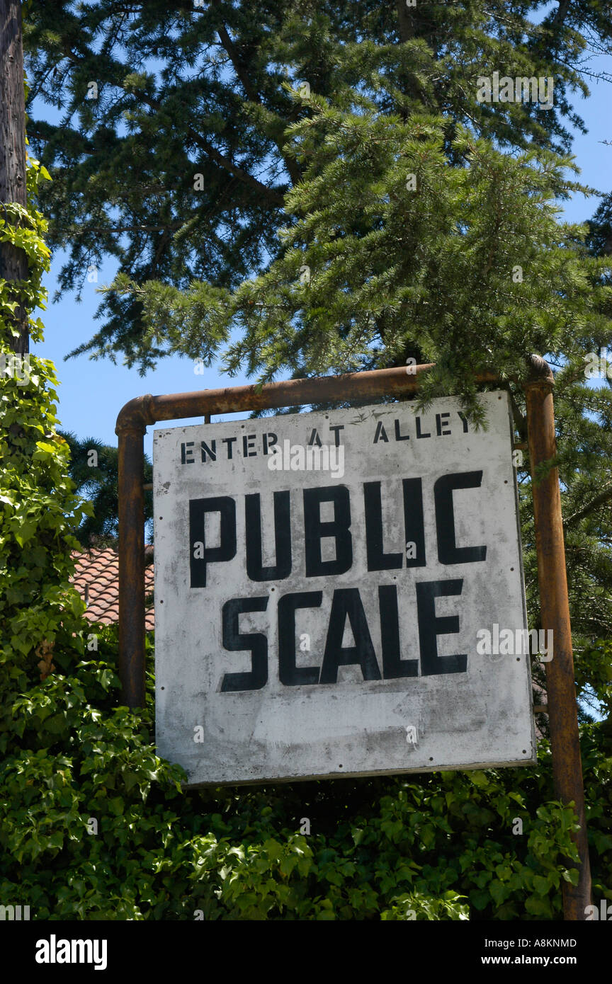 A sign indicates entry to a public scale surrounded by lush trees and ...